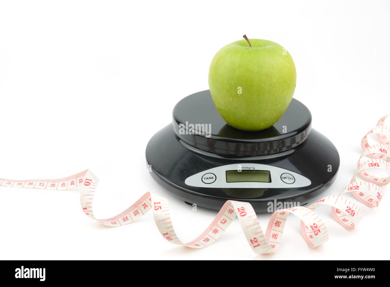 Black digital scale on isolate white background, with green apple ...