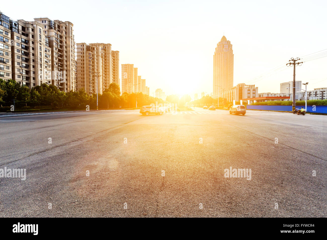 sun skyline and traffic on urban road through city buildings Stock ...