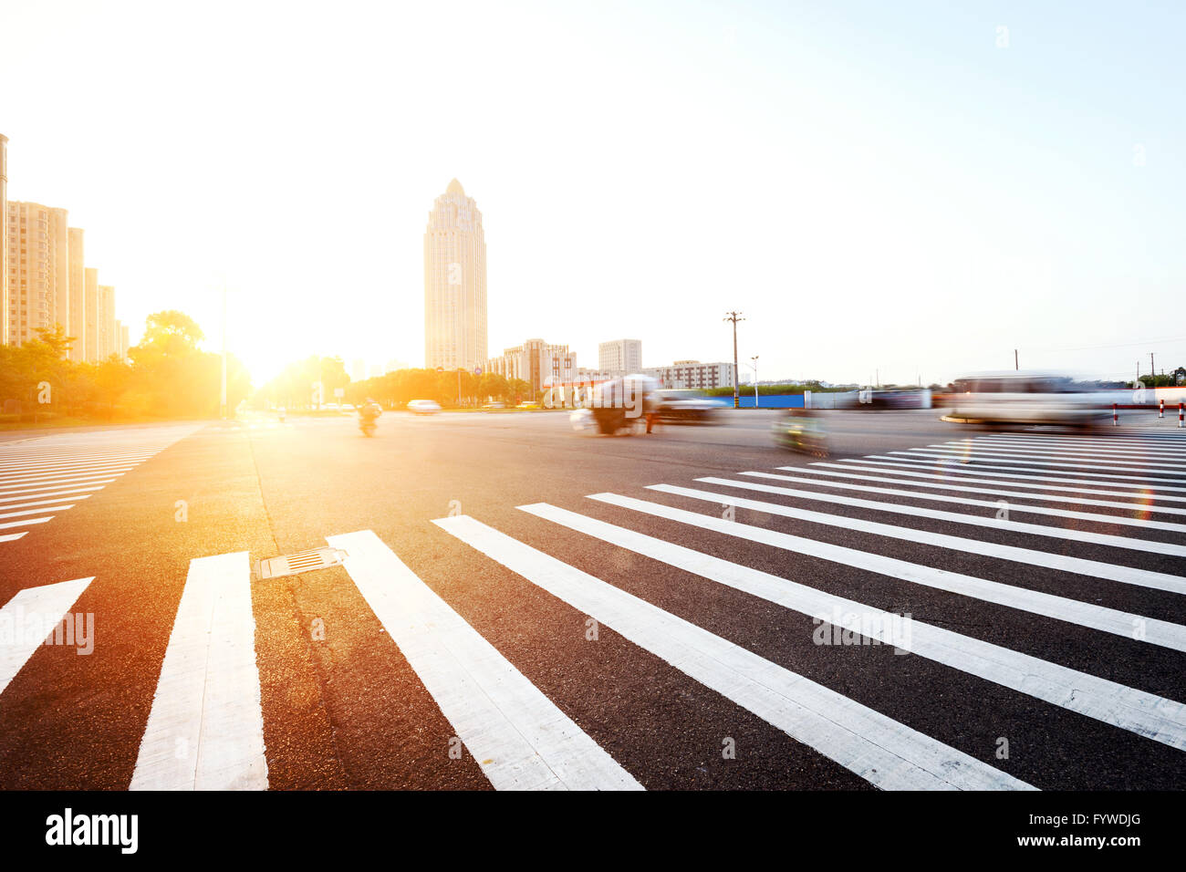 sun skyline and traffic on urban road through city buildings Stock ...