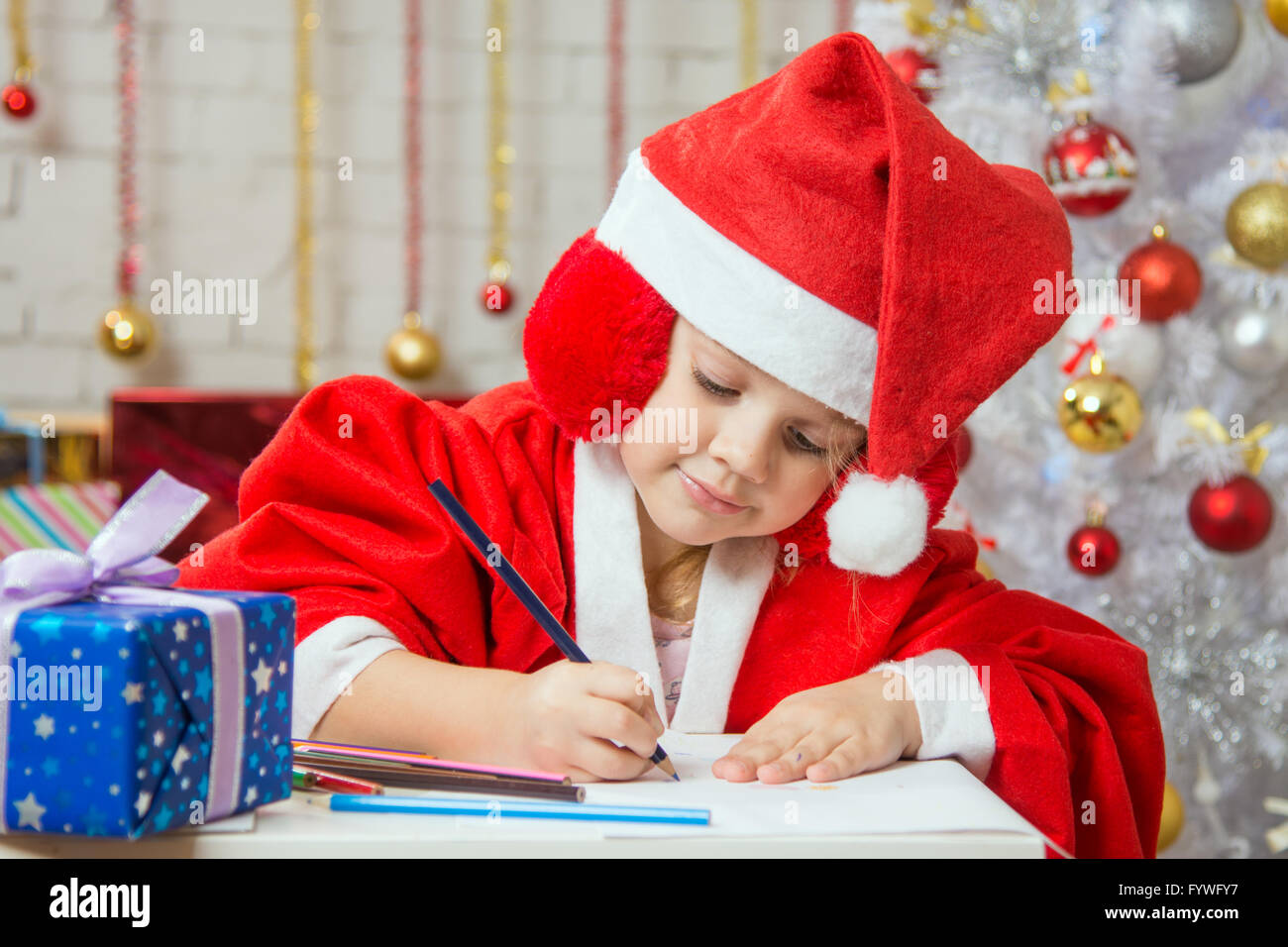 Girl with enthusiasm writes congratulations Christmas card Stock Photo ...