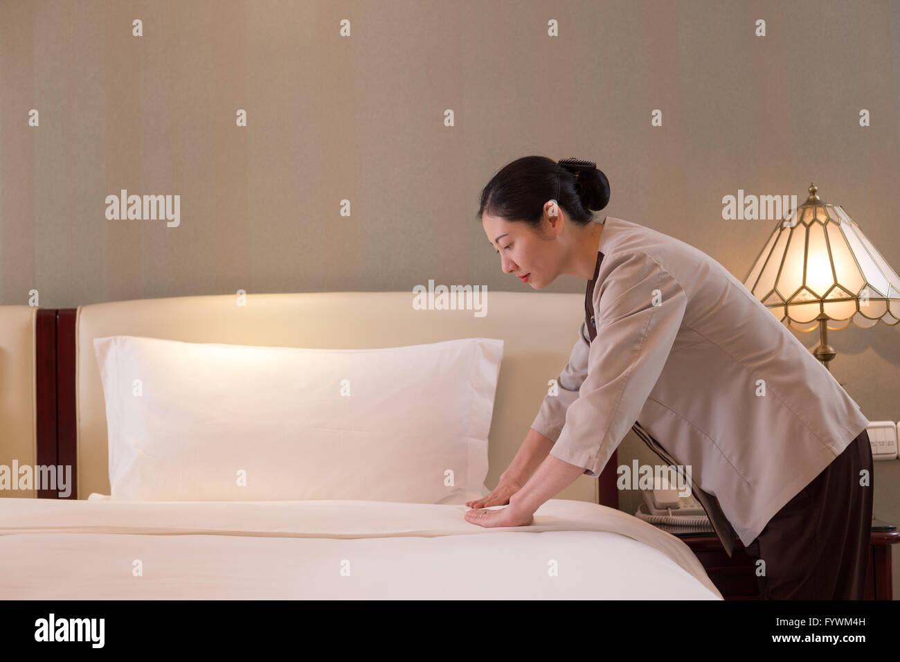 people making bed in modern bedroom Stock Photo - Alamy