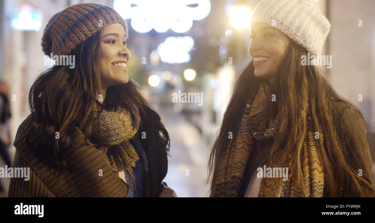 Two young woman chatting outdoors in winter Stock Photo - Alamy