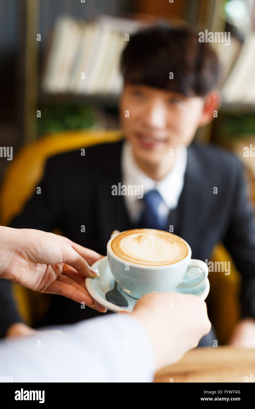 waitress serving for young customer in cafe Stock Photo - Alamy