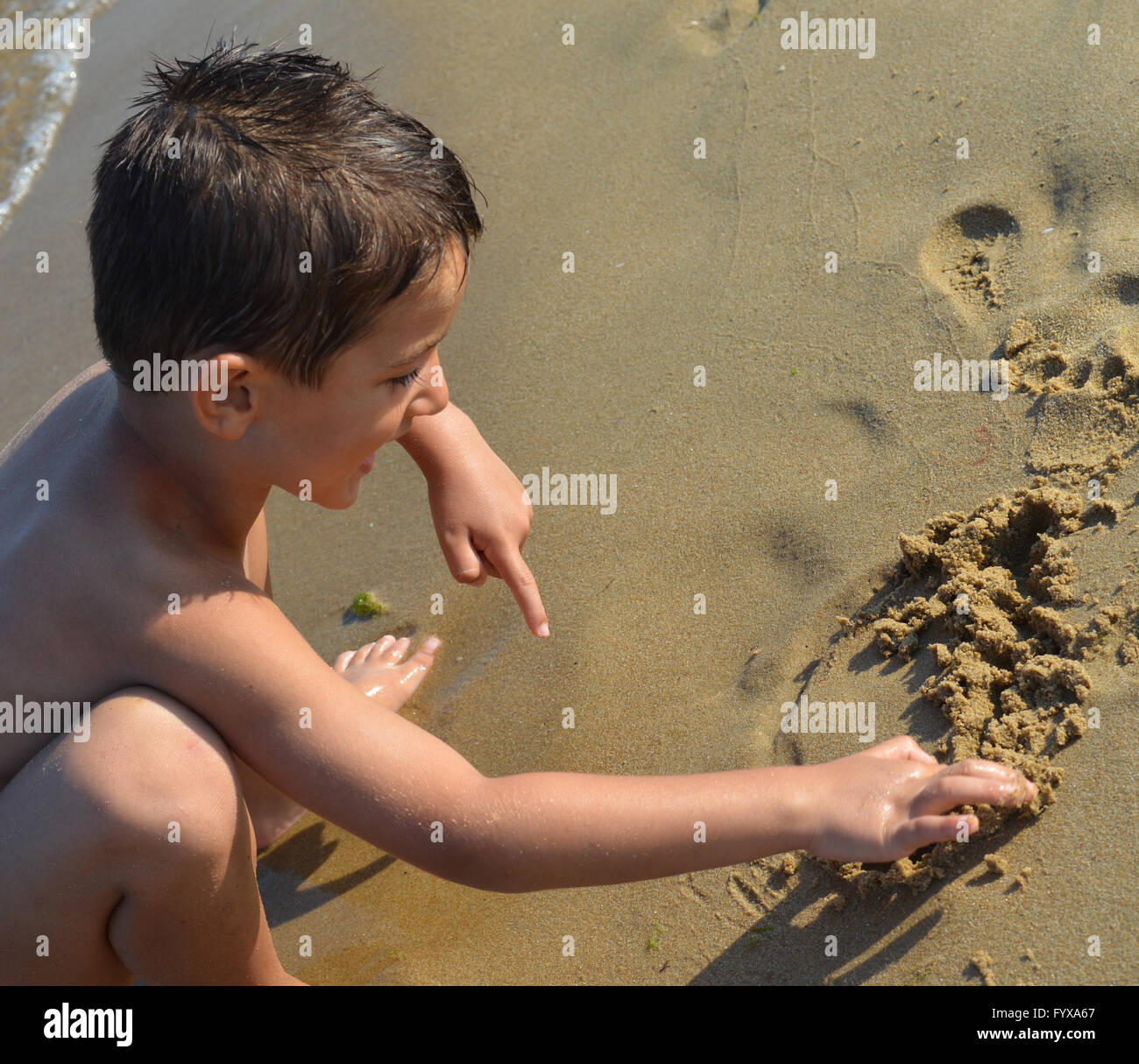 Boy drawing in the sand hi-res stock photography and images - Alamy