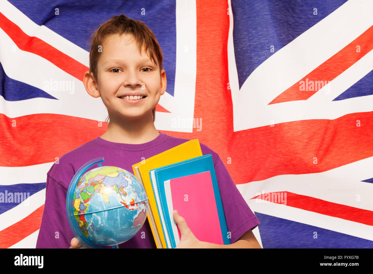 Smiling English student with globe and textbooks Stock Photo - Alamy