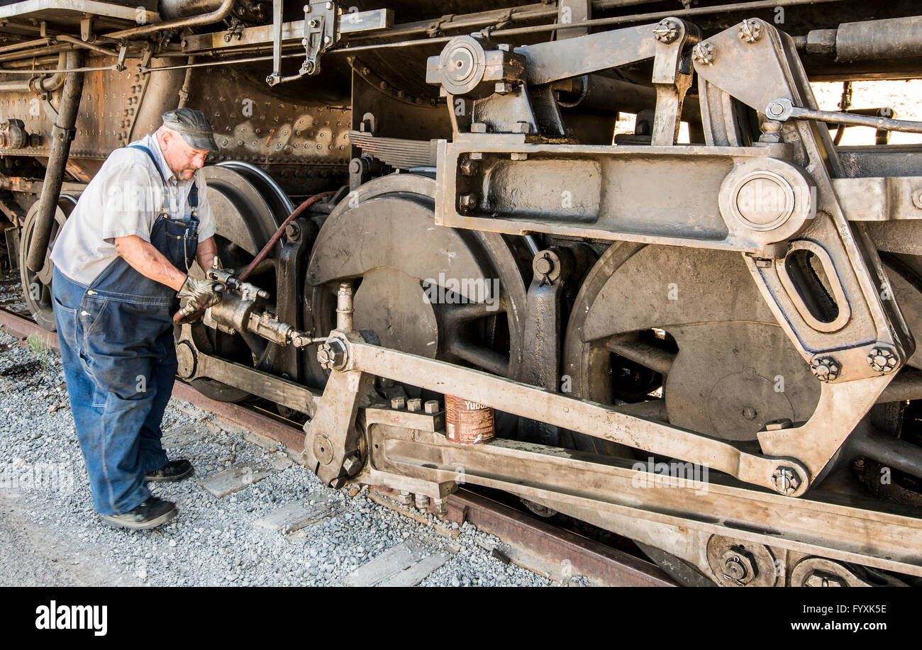 Fireman Ed Gallegos greases workings on gigantic steam engine. Virgina ...