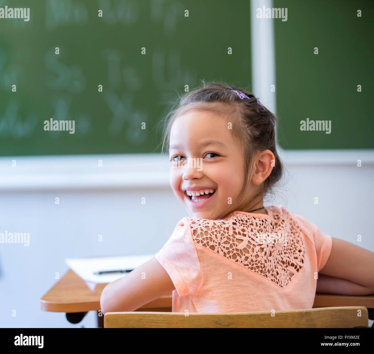Smiling girl sitting desk hi-res stock photography and images - Alamy