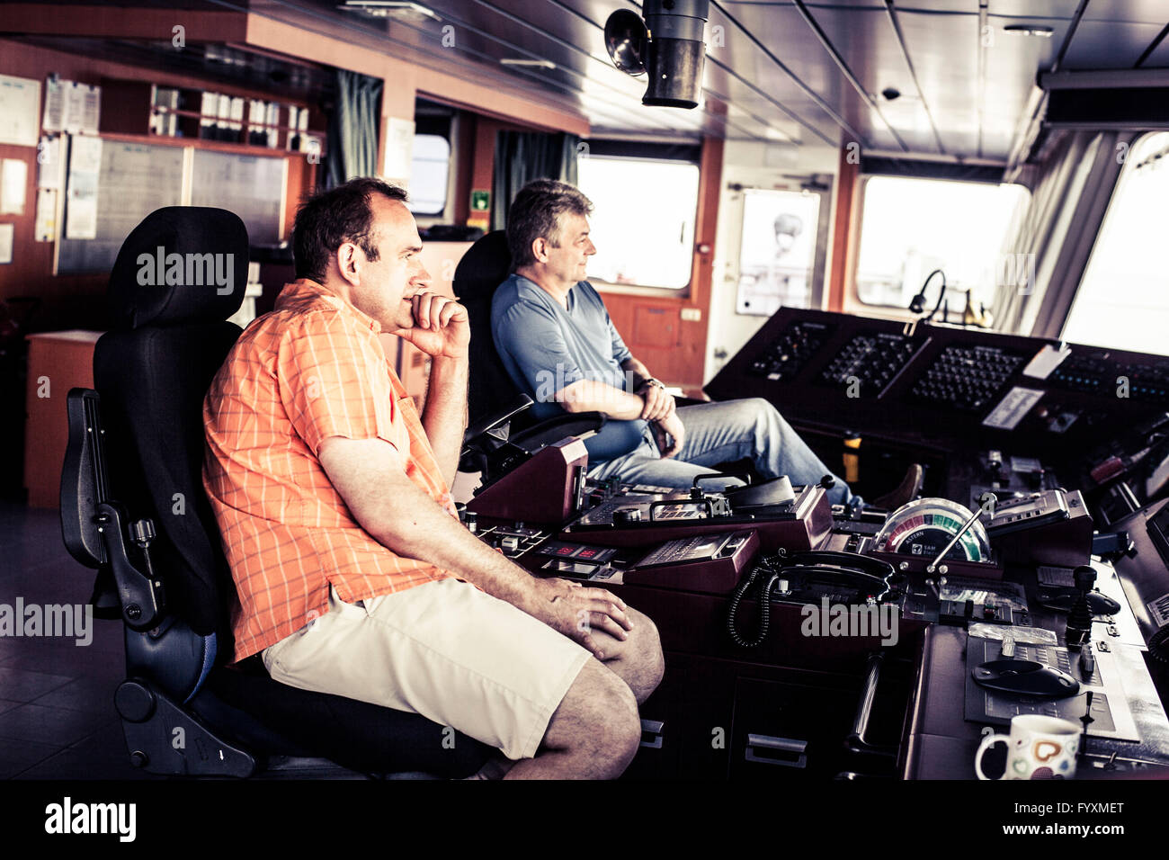 Captain and first officer sitting at the navigation deck onboard a ...