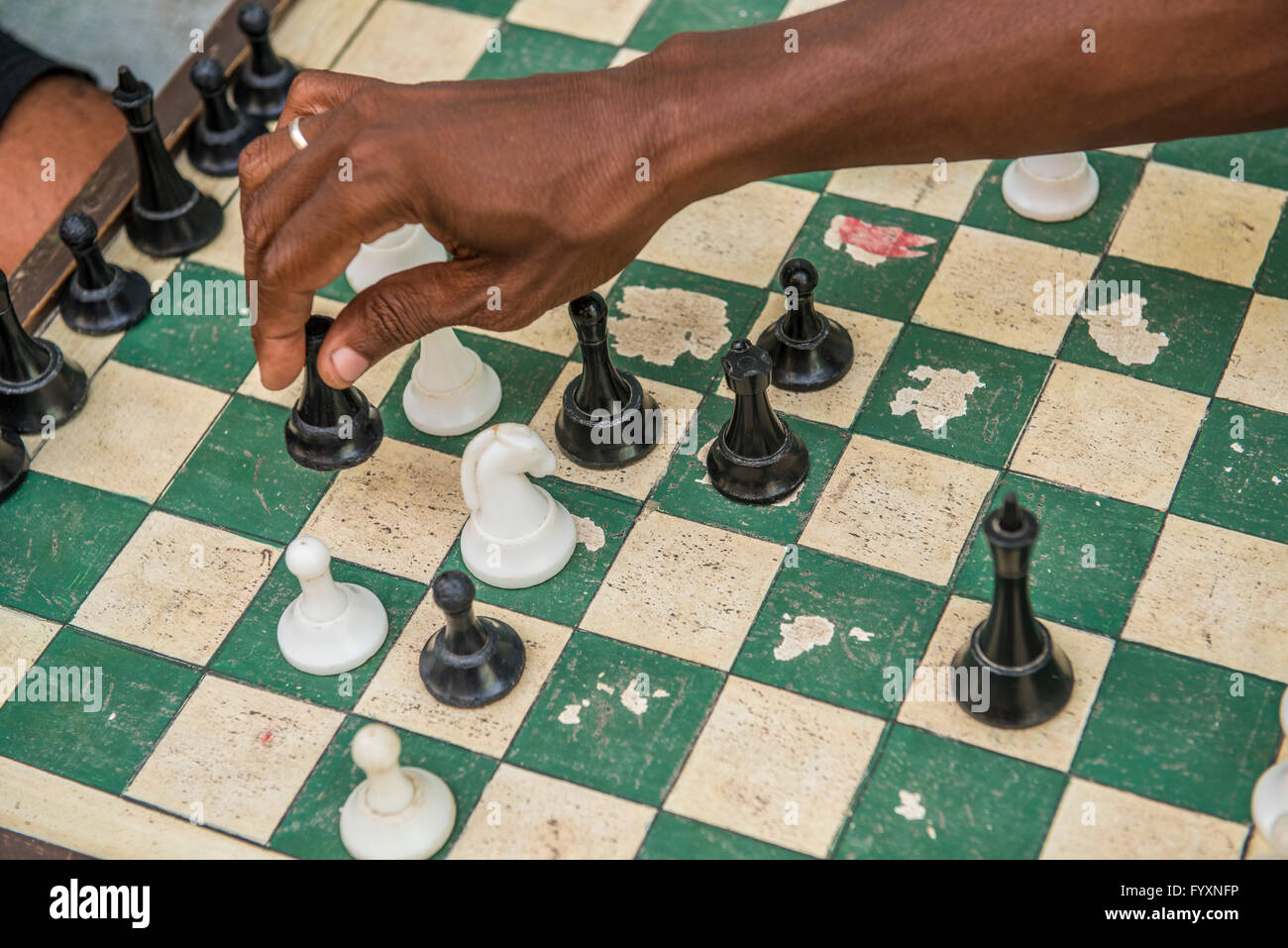 The arm of a cuban man playing street chess, seen from above. Havana ...