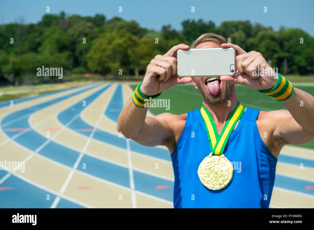 Gold medal athlete making faces at his mobile phone taking a selfie at ...