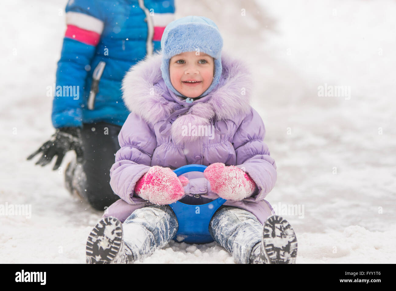 Five-year girl rolled down ice slides looked up Stock Photo - Alamy