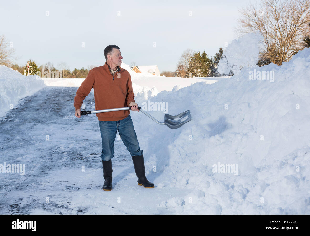 Senior adult man finishes digging out drive in snow Stock Photo - Alamy