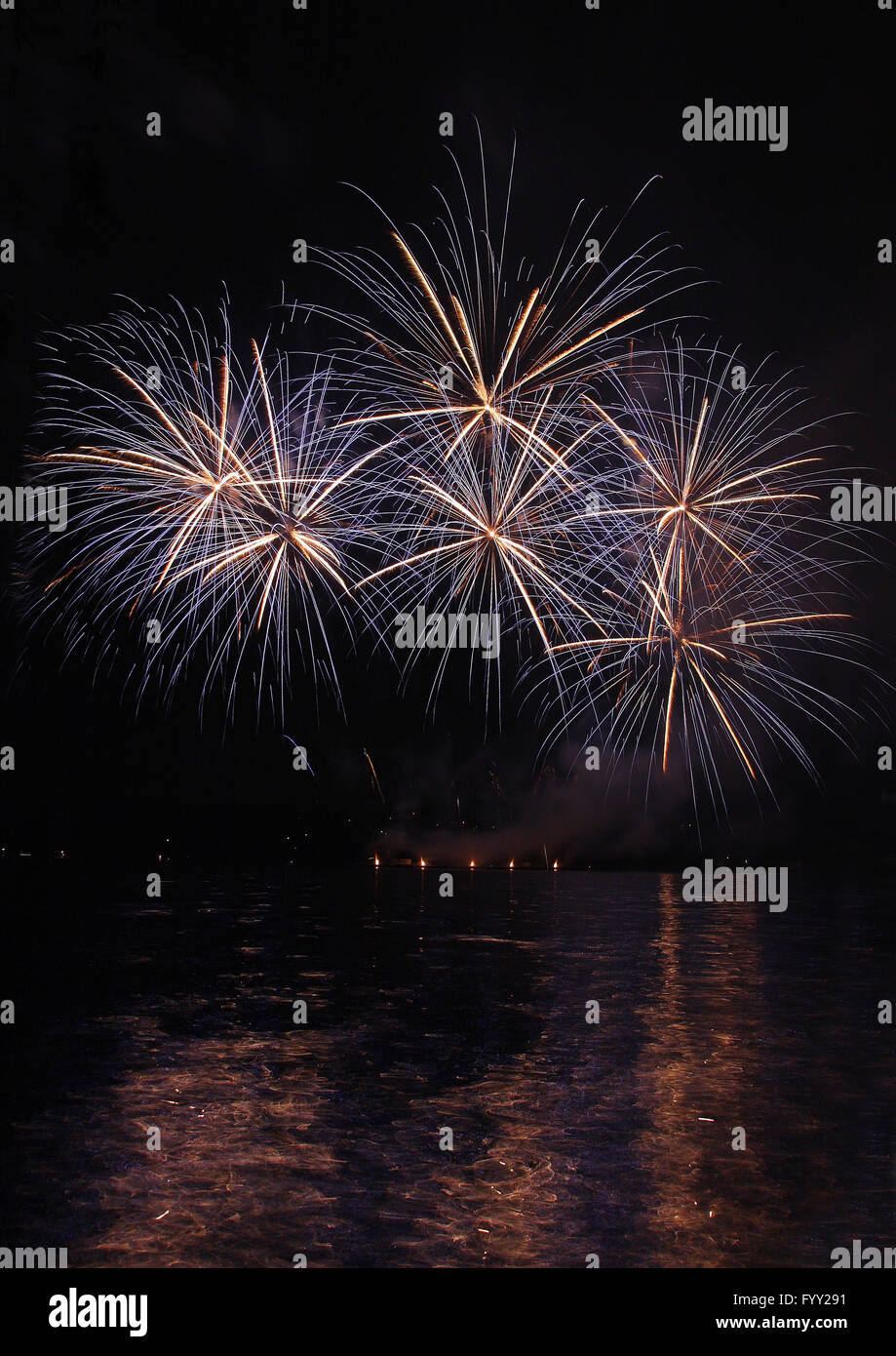 Colorful fireworks with reflection on lake and night sky in background ...