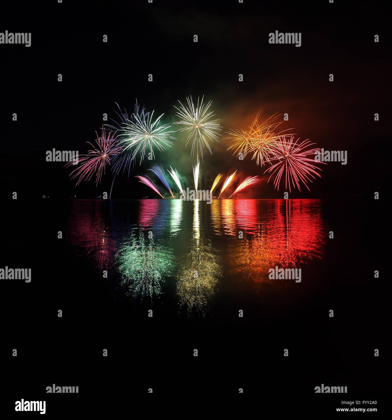 Colorful fireworks with reflection on lake and night sky in background ...