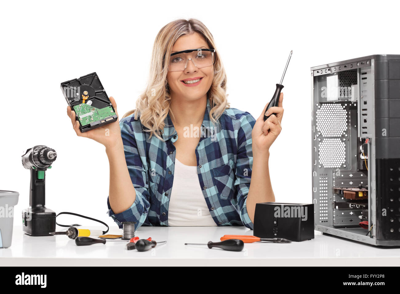 Cheerful female IT technician holding a computer part and a screwdriver ...