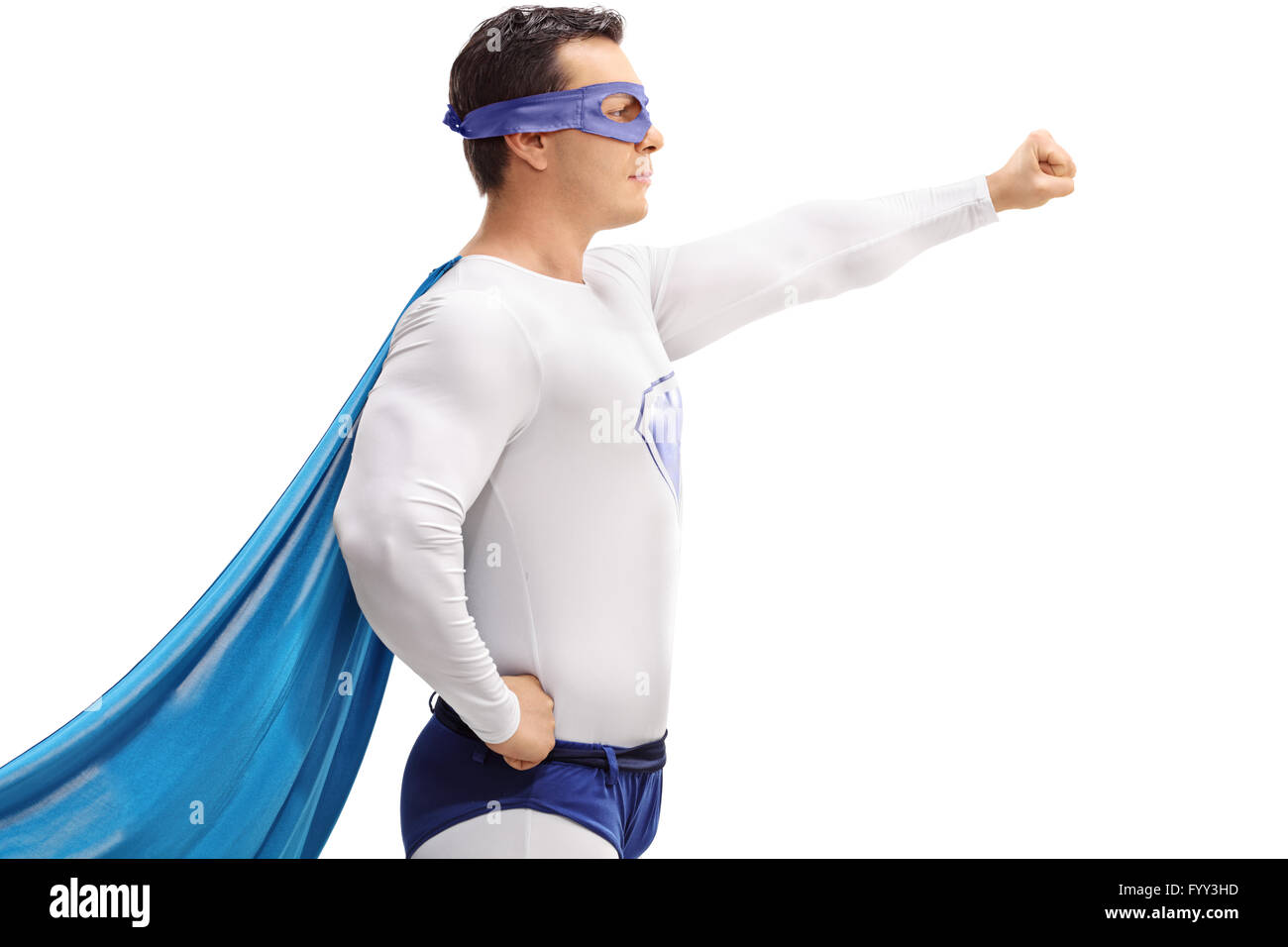 Profile shot of a young man in a superhero outfit holding a gripped ...