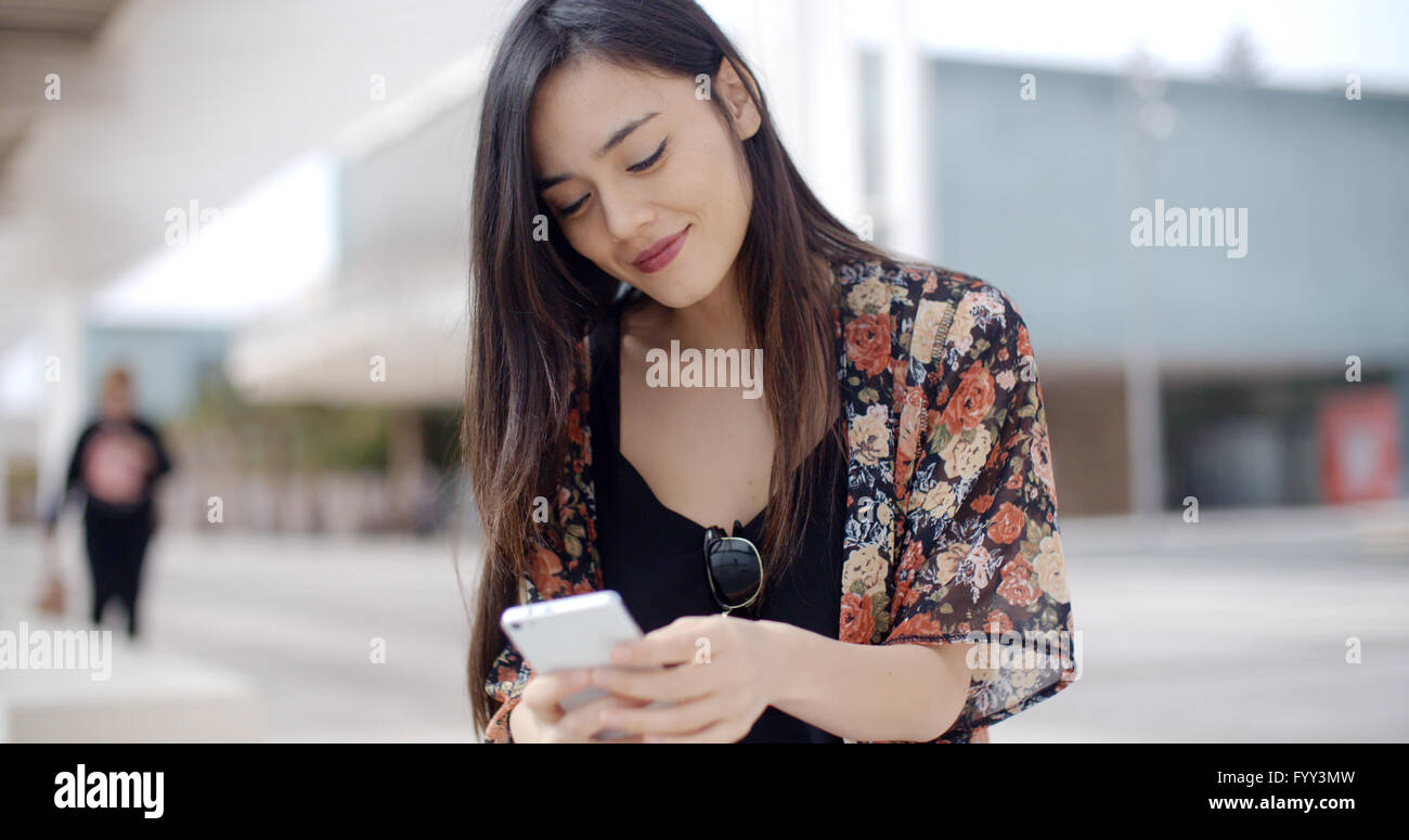 Young woman sitting reading a text message Stock Photo - Alamy