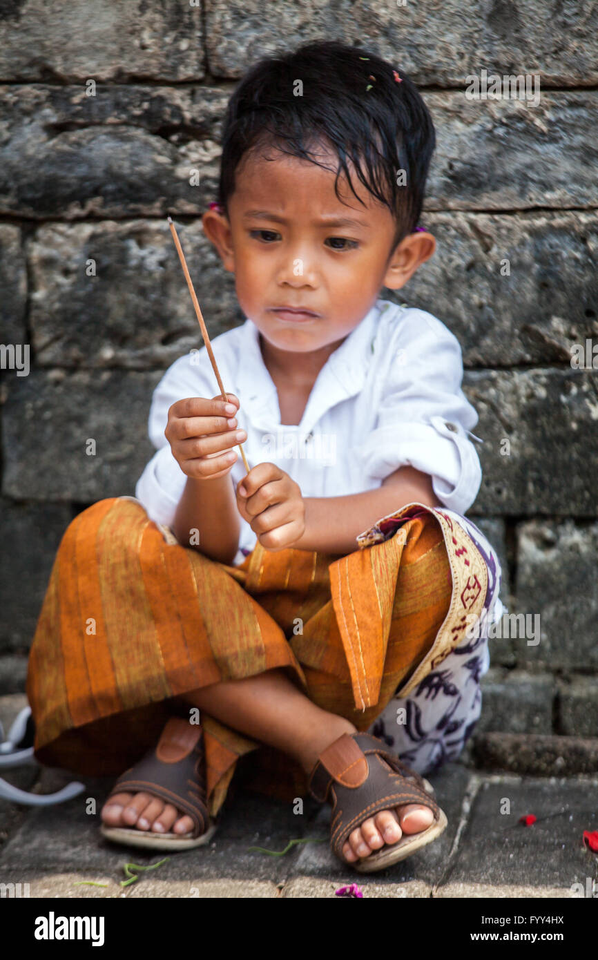 Balinese kid at a Hindu ceremony sits quietly contemplating Stock Photo ...