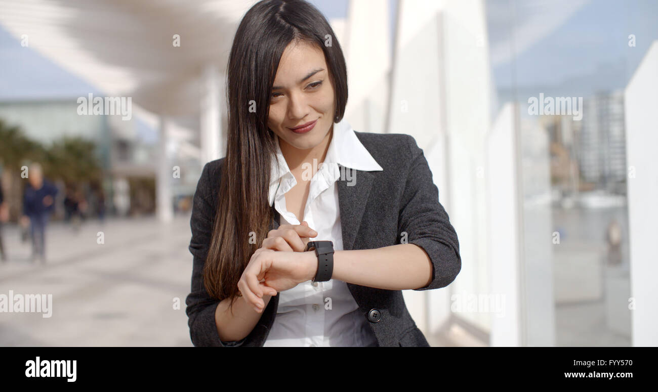 Young woman checking her wristwatch for the time Stock Photo - Alamy