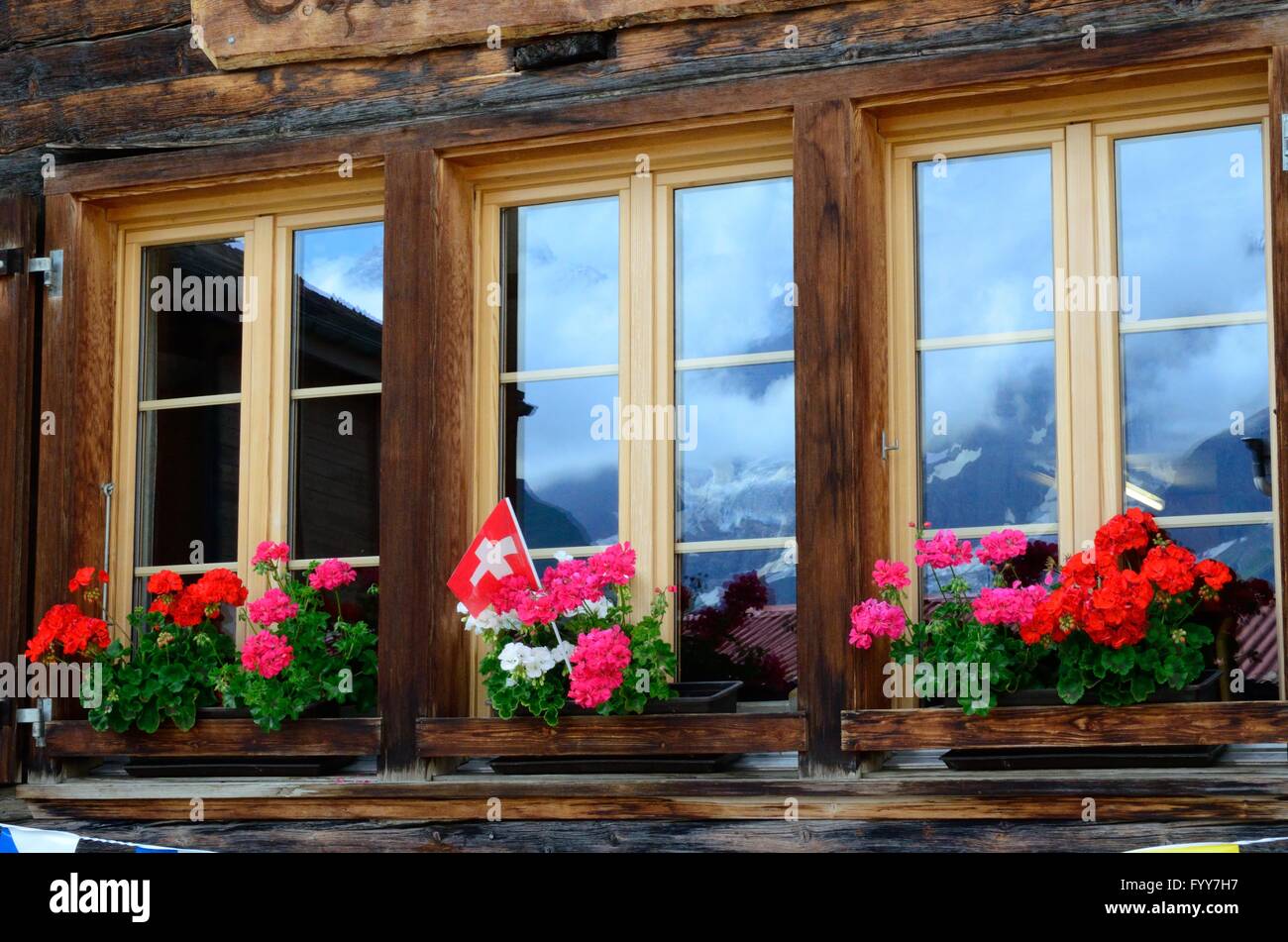 Reflections of the Swiss Alps in Chalet window Stock Photo - Alamy