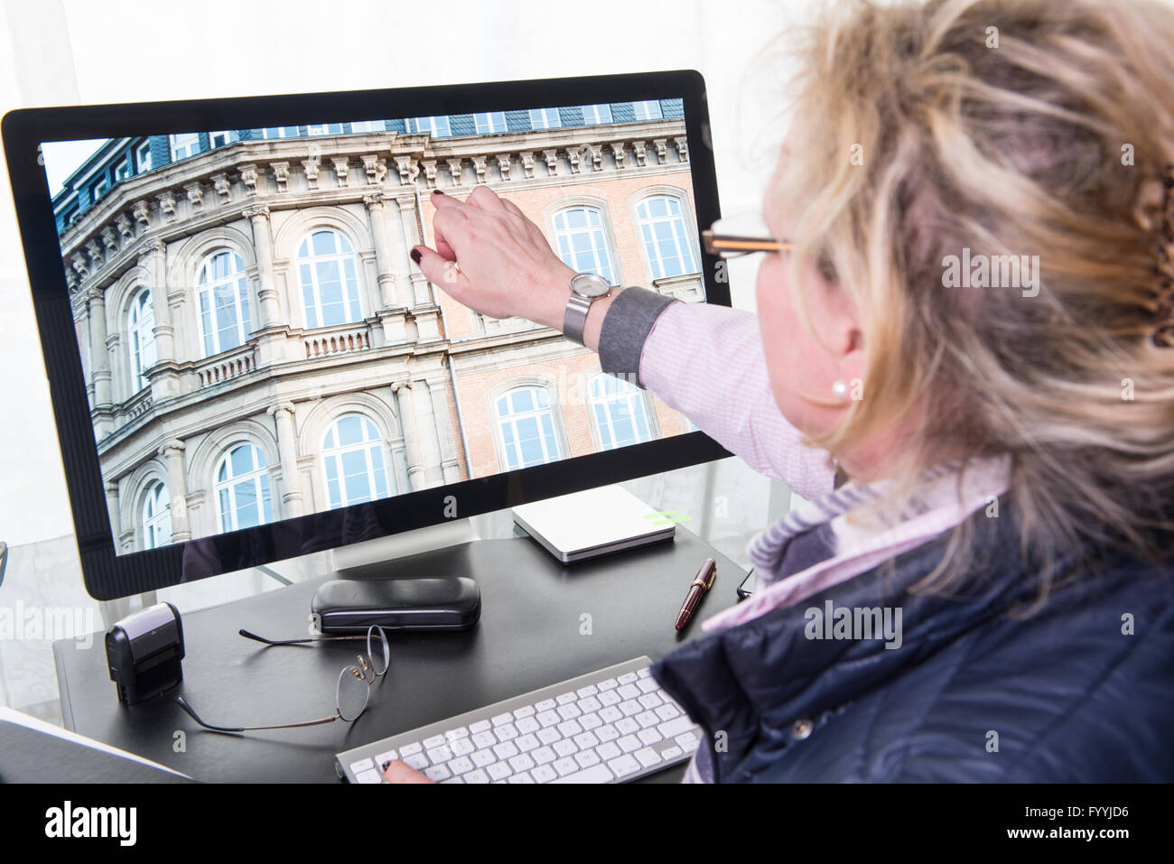 female architect pointing to part of project on big computer screen ...