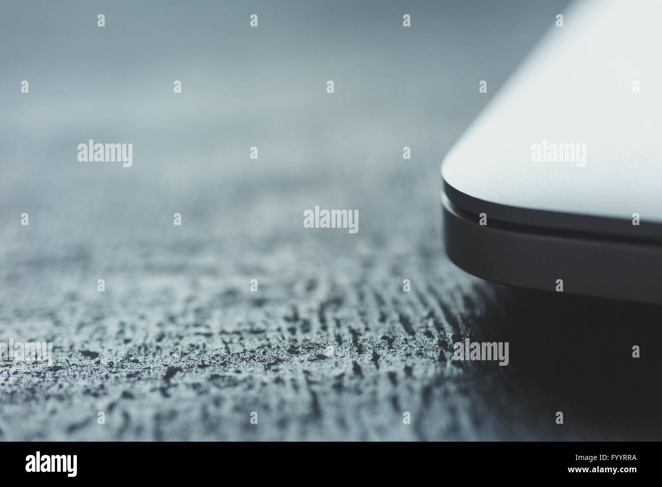 Closed laptop on modern wooden desk Stock Photo - Alamy