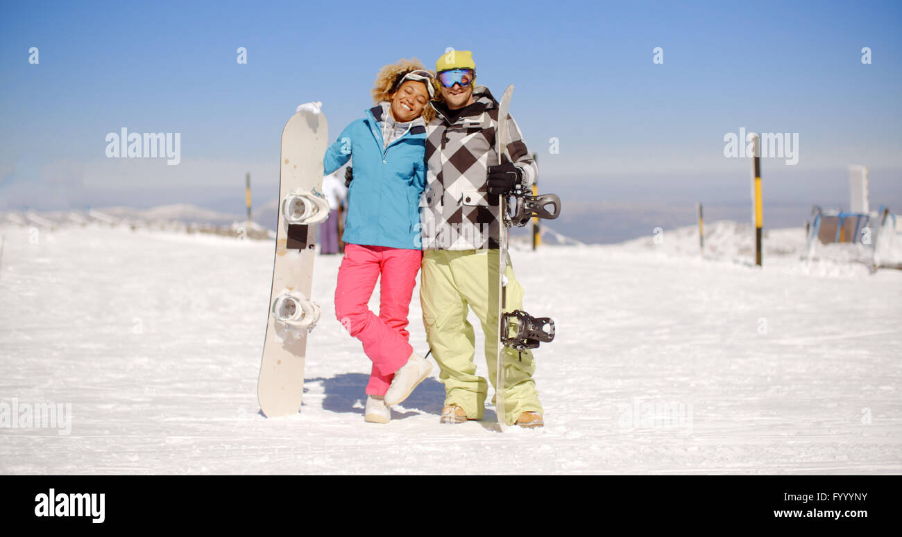 Happy young couple posing with their snowboards Stock Photo - Alamy