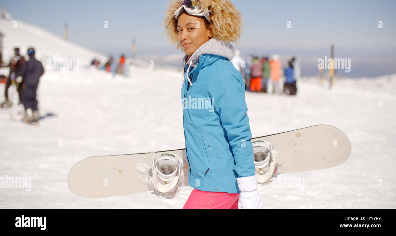 Trendy young woman carrying her snowboard Stock Photo - Alamy