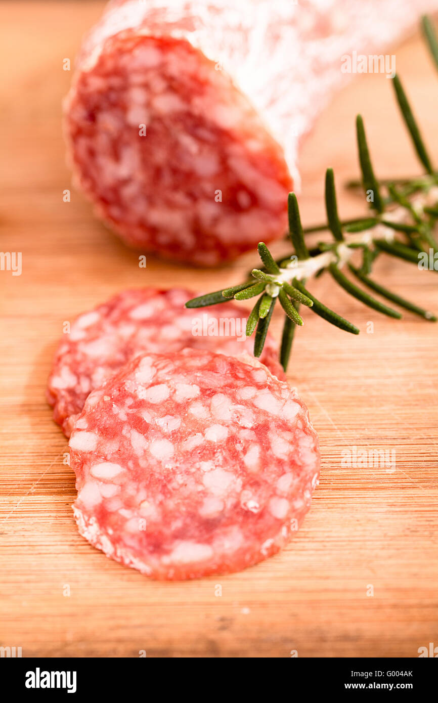Two discs of salami with a branch rosemary Stock Photo - Alamy