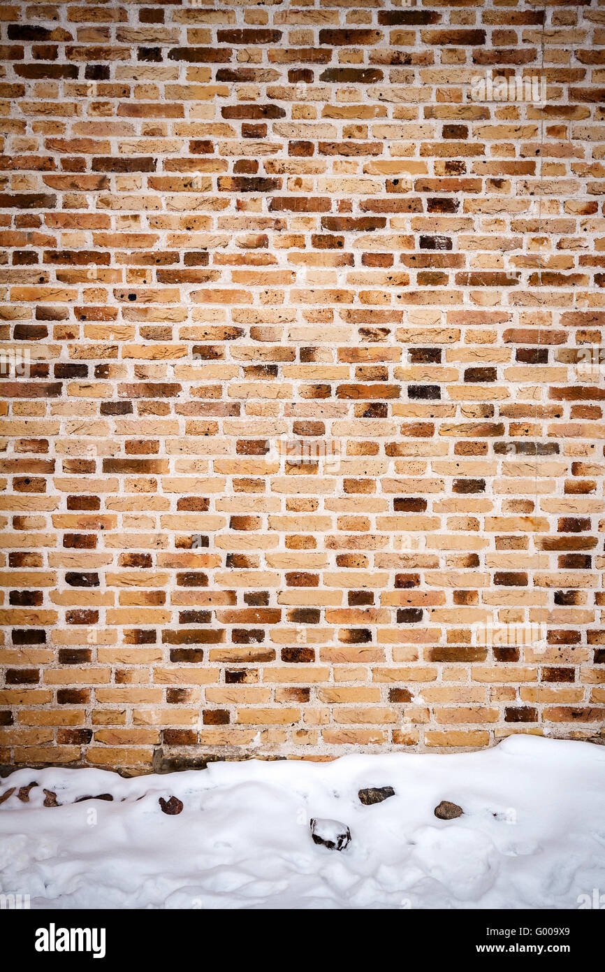 Yellow brick wall and a ground covered with snow Stock Photo - Alamy