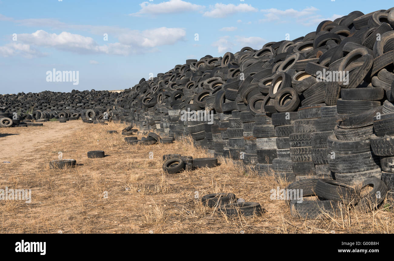 Old used rubber tires piled in a recycling yard waiting to be shredded ...