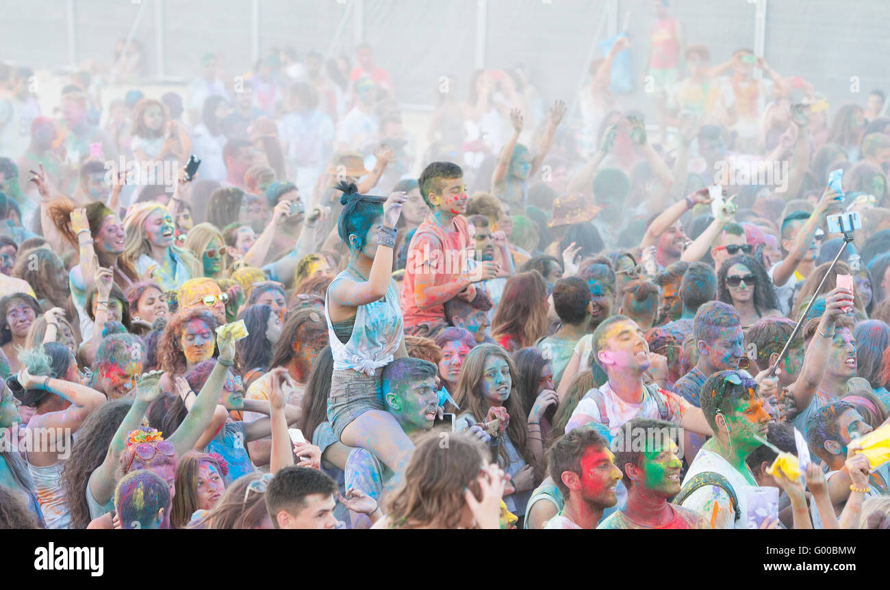 People with colored faces and bodies dancing and enjoying the Color War ...