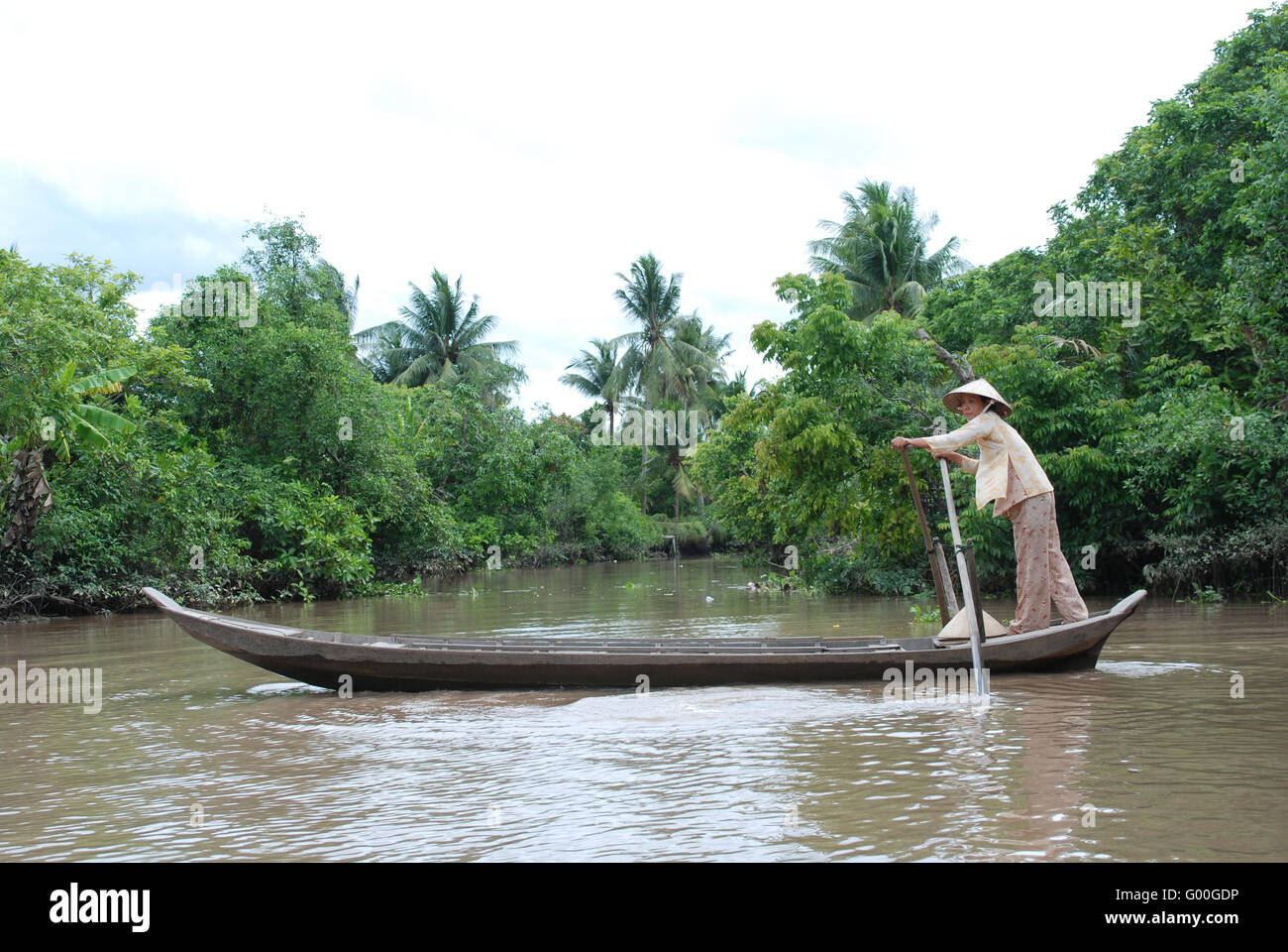 Vietnamese woman rowing a boat in Mekong River Stock Photo - Alamy