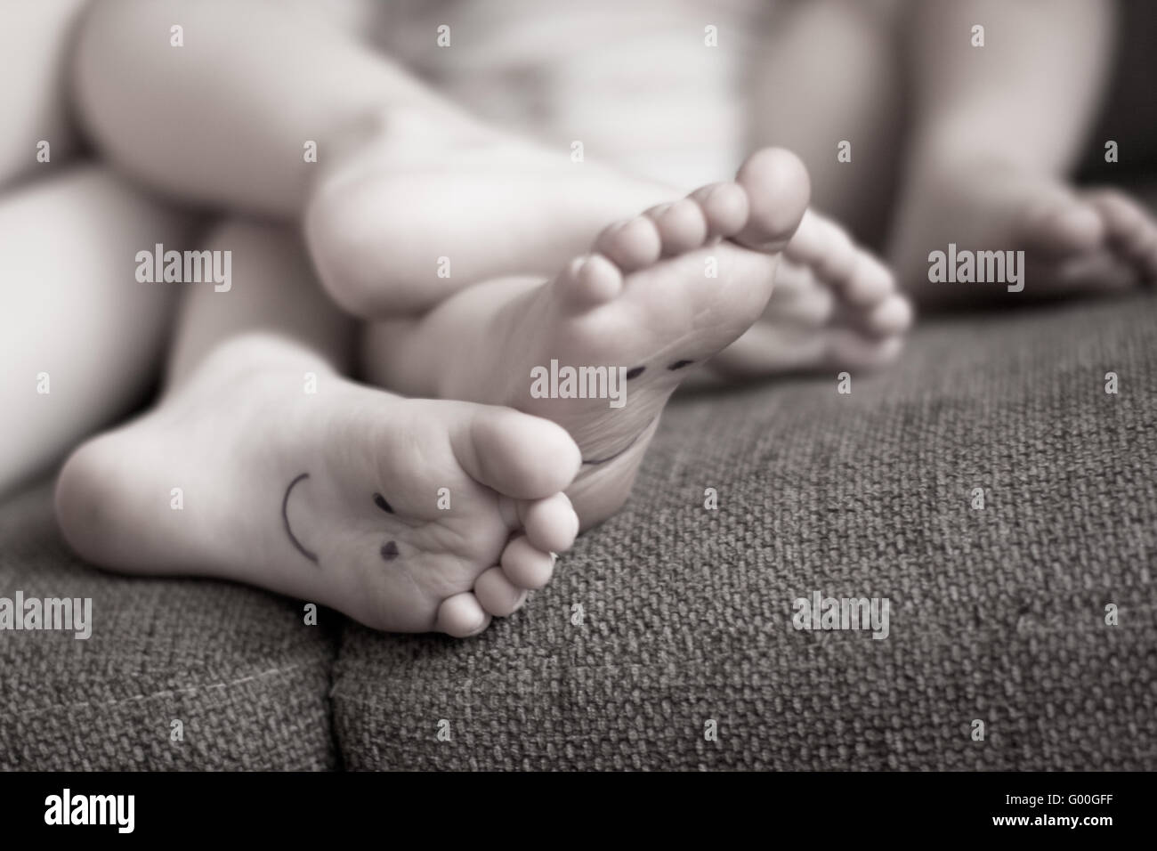 Little childrens feet while relaxing on couch Stock Photo - Alamy