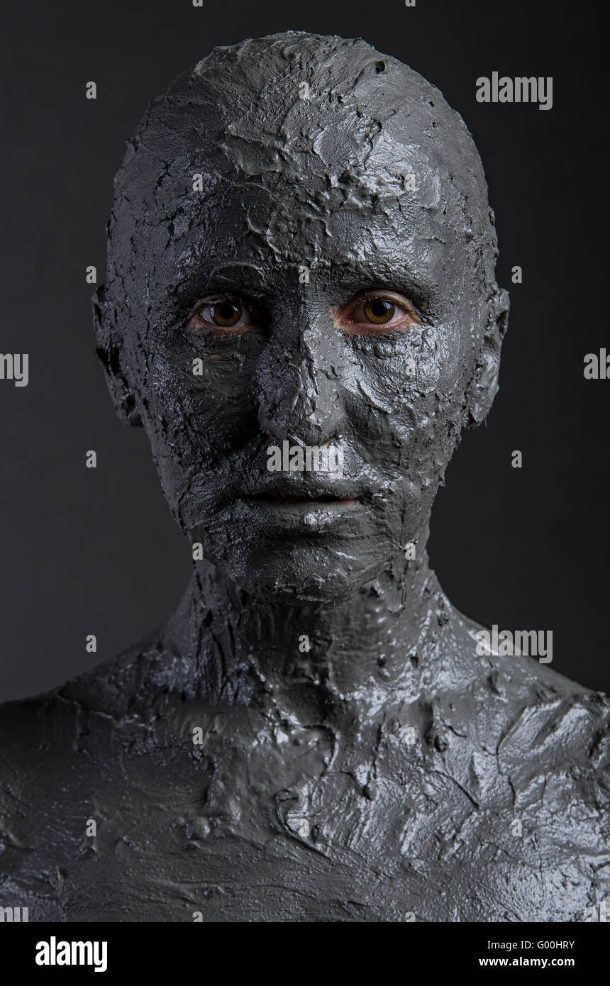 Statuesque woman in wet clay. Woman covered in wet clay. Spa treatment ...