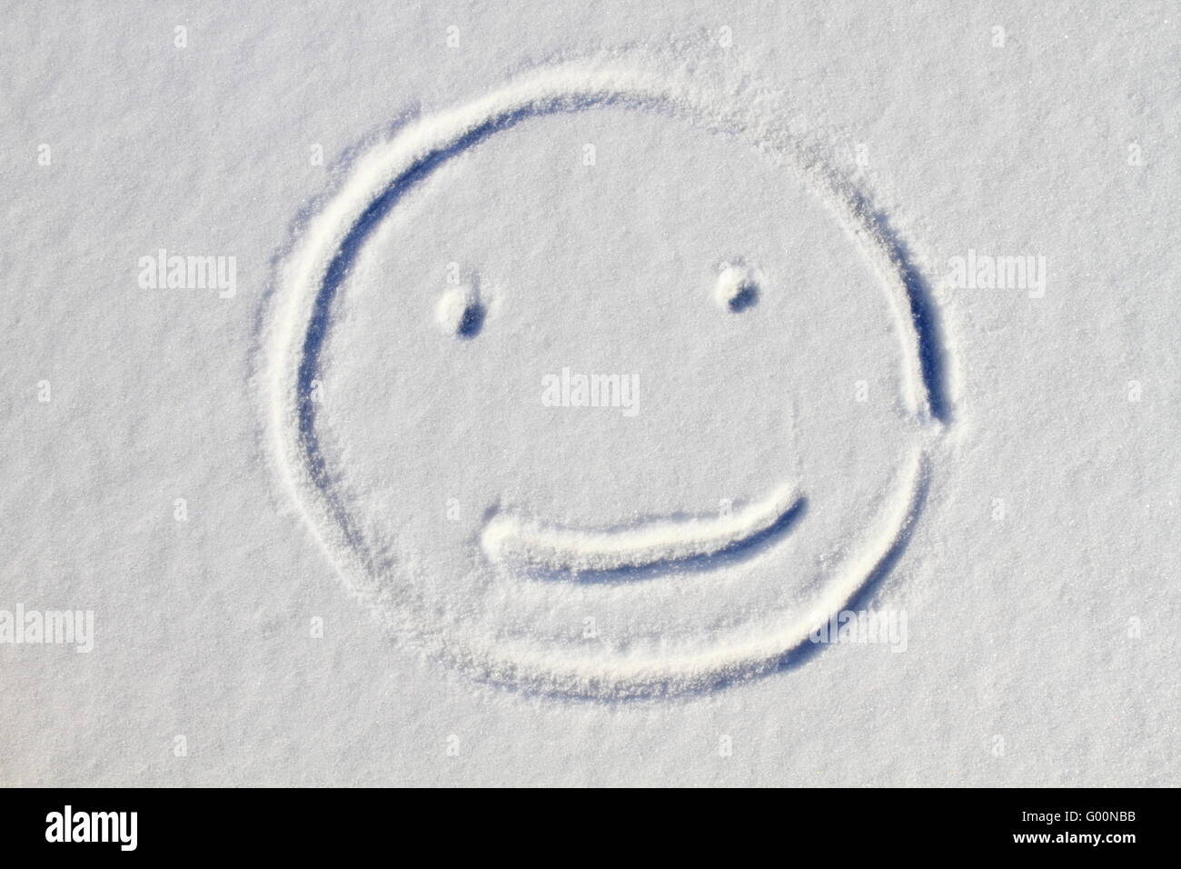 Smiley face drawn on snow background Stock Photo - Alamy