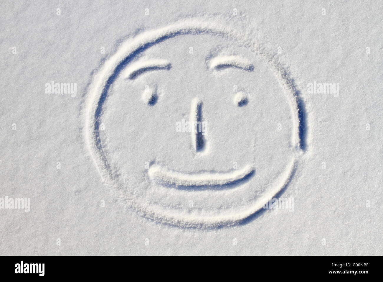 Smiley face drawn on snow background Stock Photo - Alamy