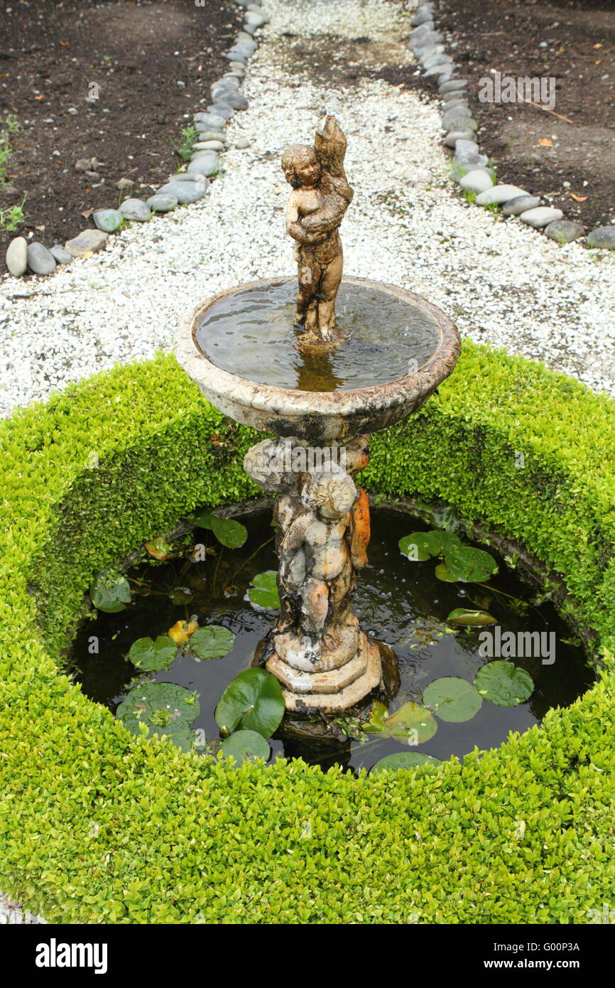 Picturesque little fountain in the garden Stock Photo - Alamy