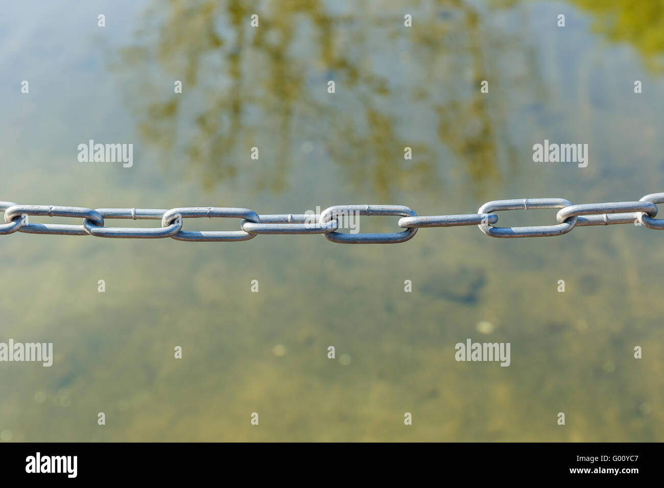Metal chain limiting access to water Stock Photo - Alamy
