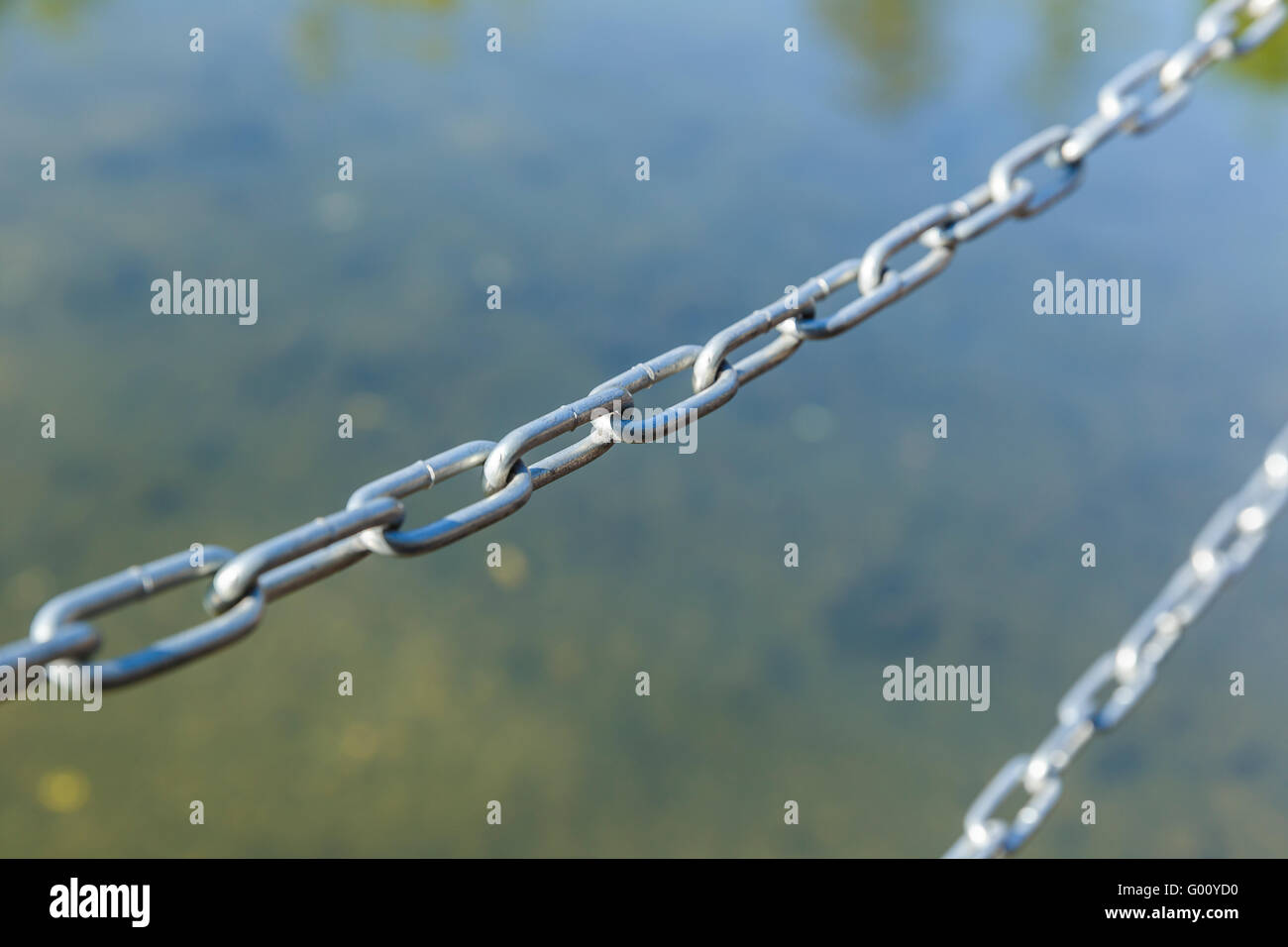 Metal chain limiting access to water Stock Photo - Alamy