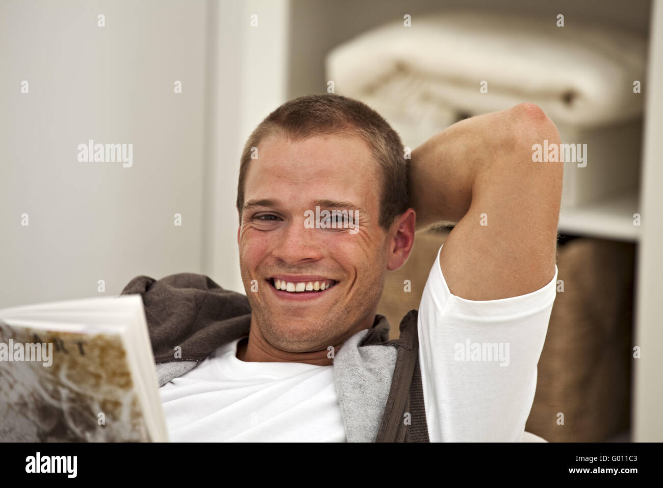 smiling young man reading a book Stock Photo - Alamy