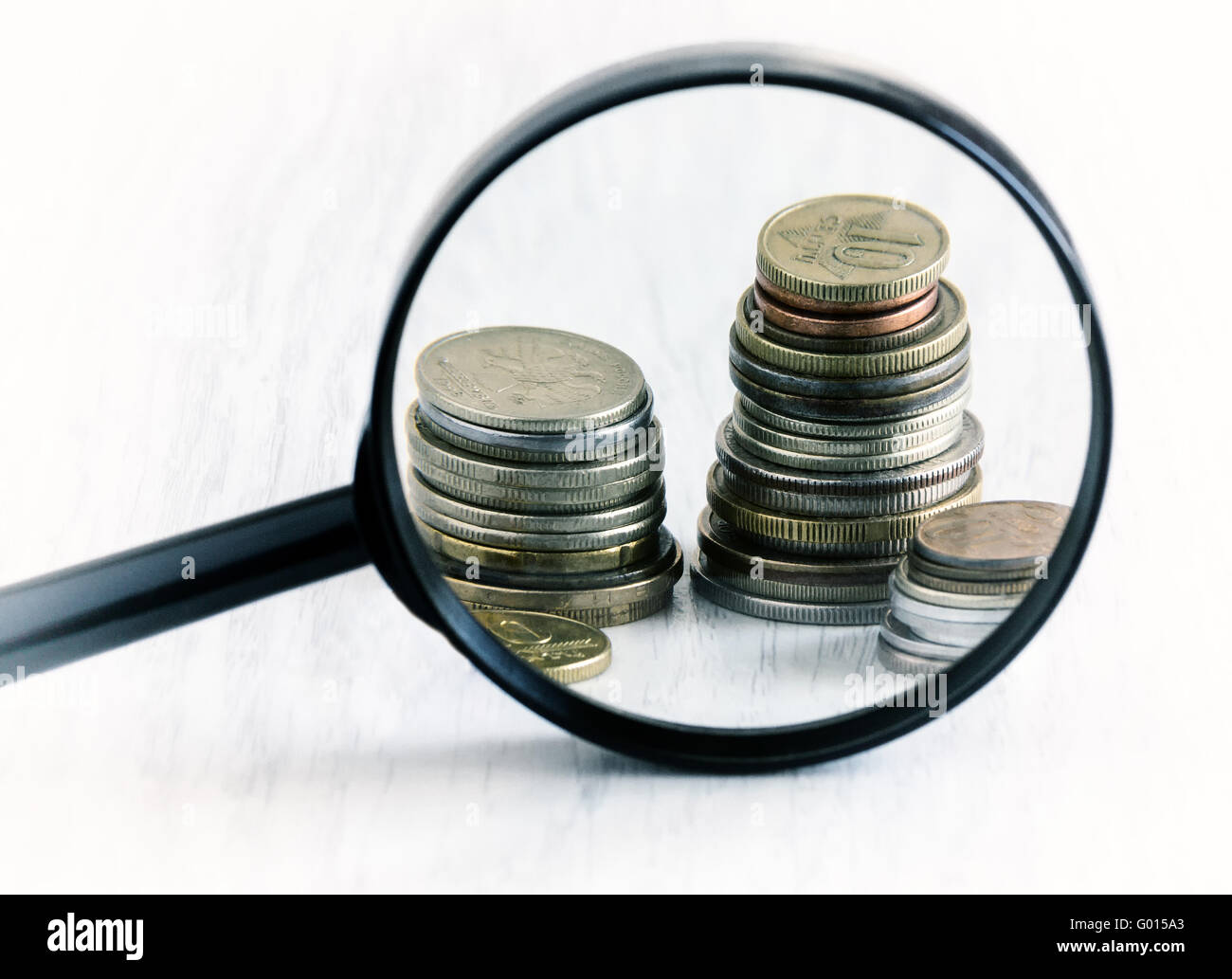 Magnifying glass coins background Cut Out Stock Images & Pictures - Alamy