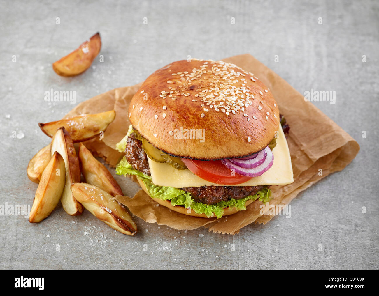 Classic cheeseburger and potato wedges on gray table Stock Photo - Alamy