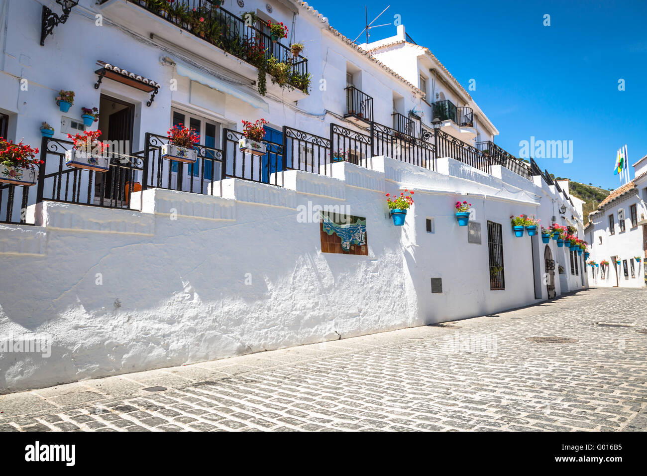 Picturesque street of Mijas with flower pots in facades. Andalusian ...