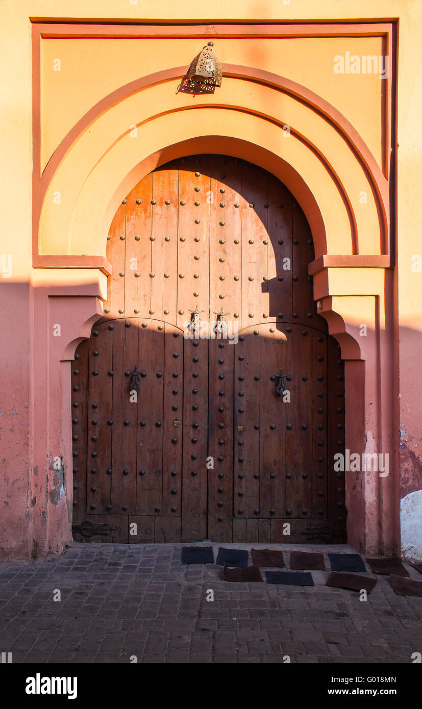 Heavy wooden gate with traditional decoration. Arch on the top. Warm ...