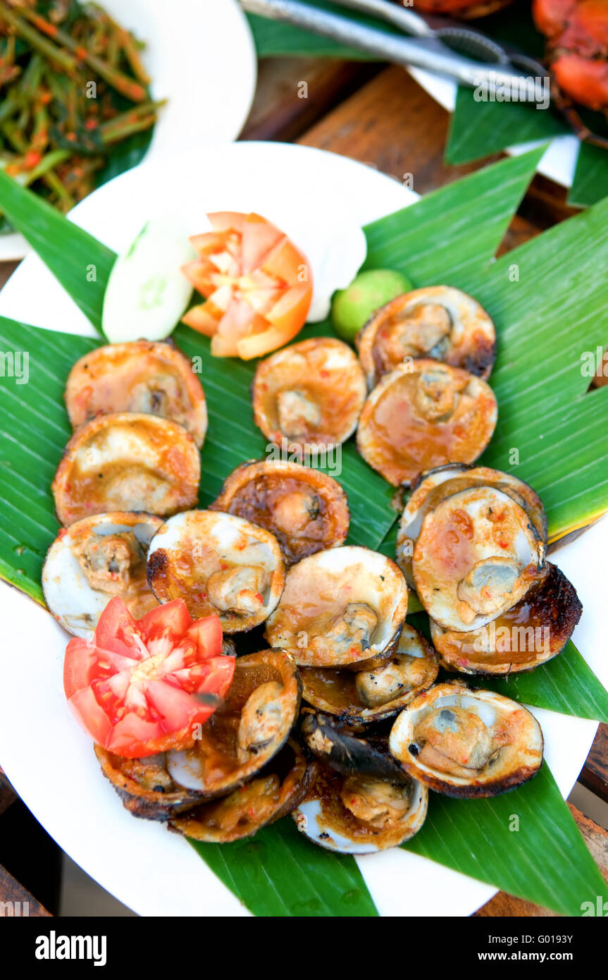 Grilled shell fish split in shell with garnish Stock Photo - Alamy