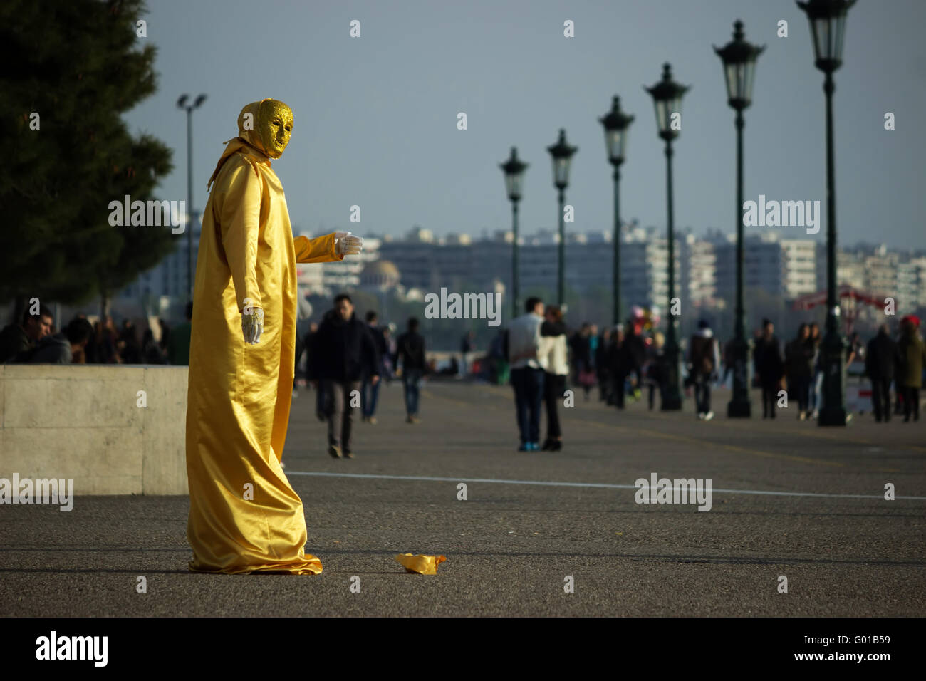 A street mime artist wearing a gold sequin dress performing live on ...