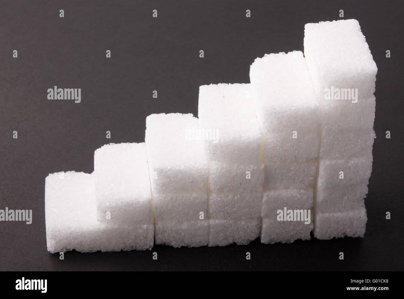 Ladder from lump sugar on the black background Stock Photo - Alamy