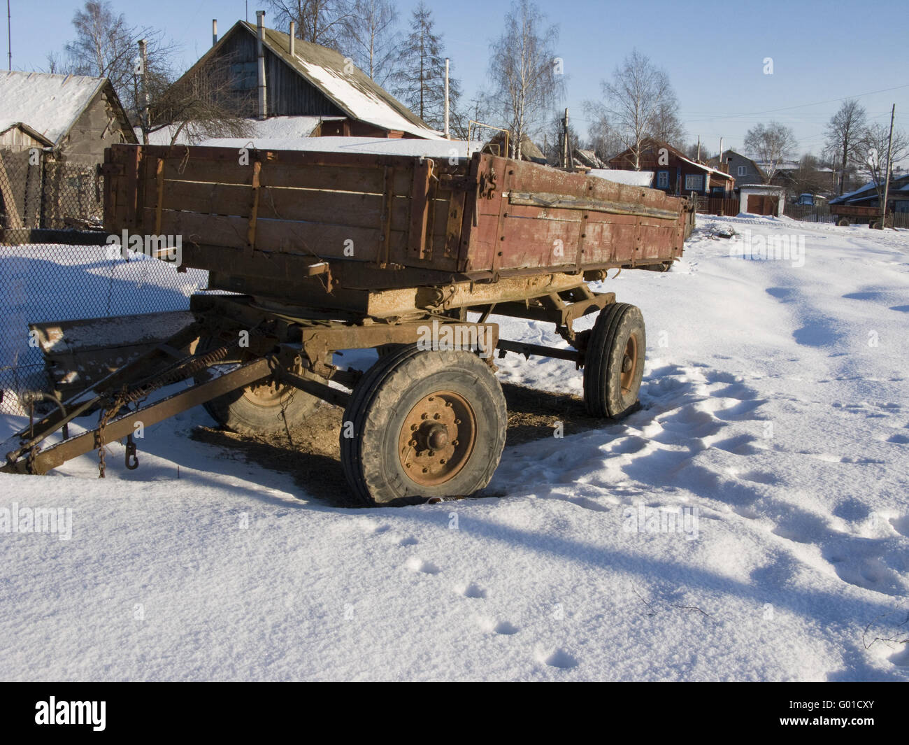 Abandoned rusty farm trailer under snow in russian village Stock Photo ...