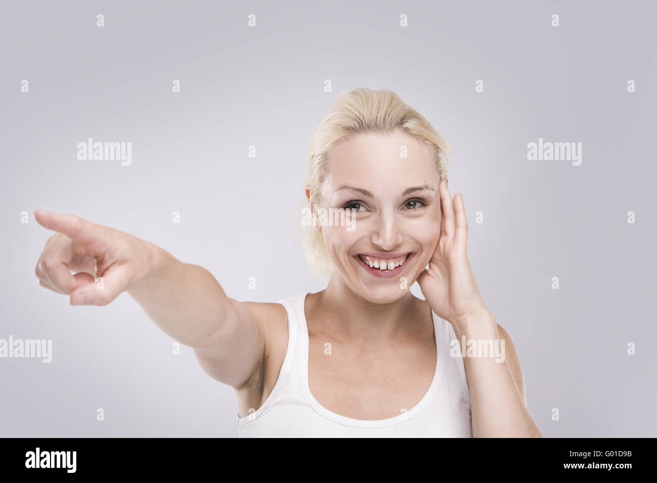 Pretty young female pointing away isolated on white background Stock ...
